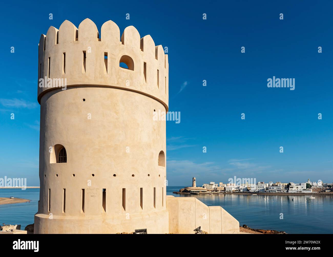 Old Watchtower with lighthouse ion the background, Al-Ayjah, Sur, Oman ...