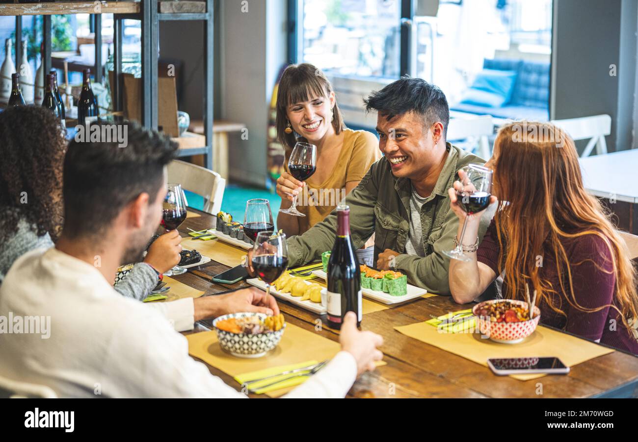 Young people dining and having fun drinking red wine together at ...