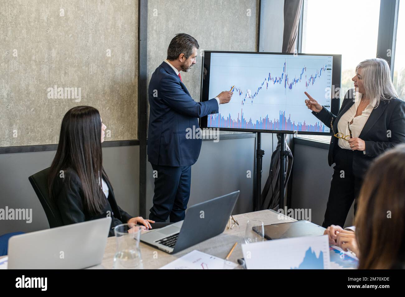 Senior business woman and man explaining company charts and statements ...