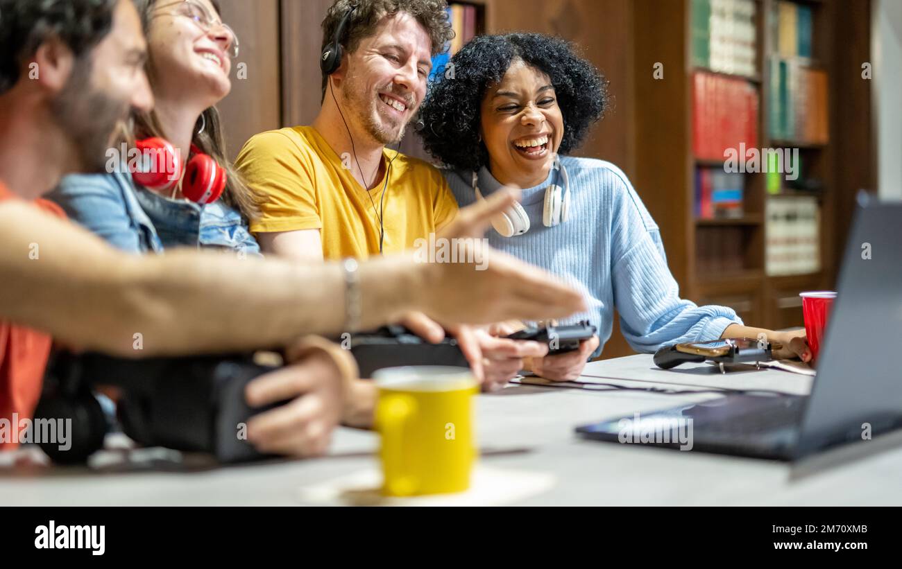 Friends playing video games on line at home, four people having fun and ...