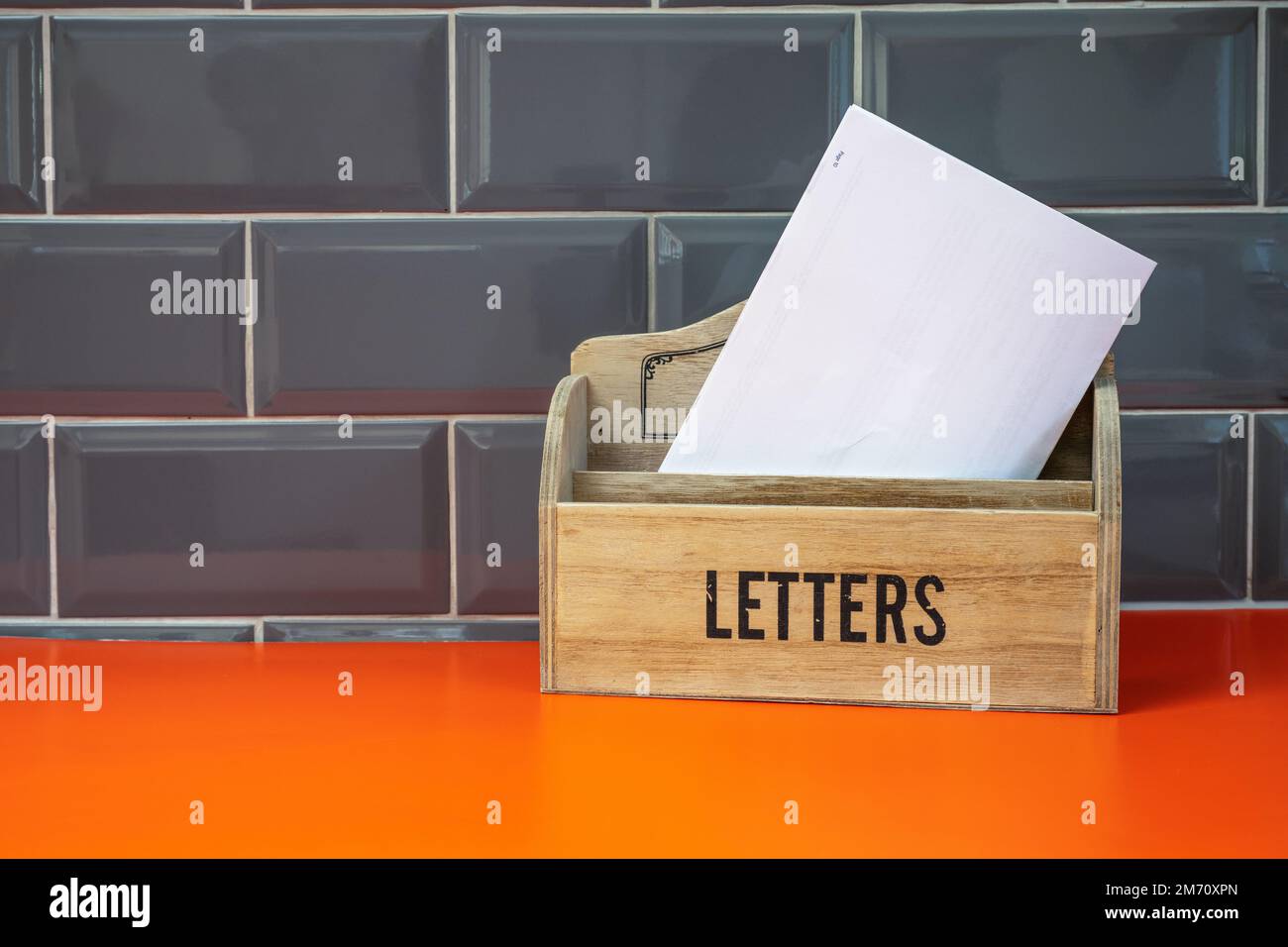 mail letter rack with blank paper on a red desk top and tiled walls ...