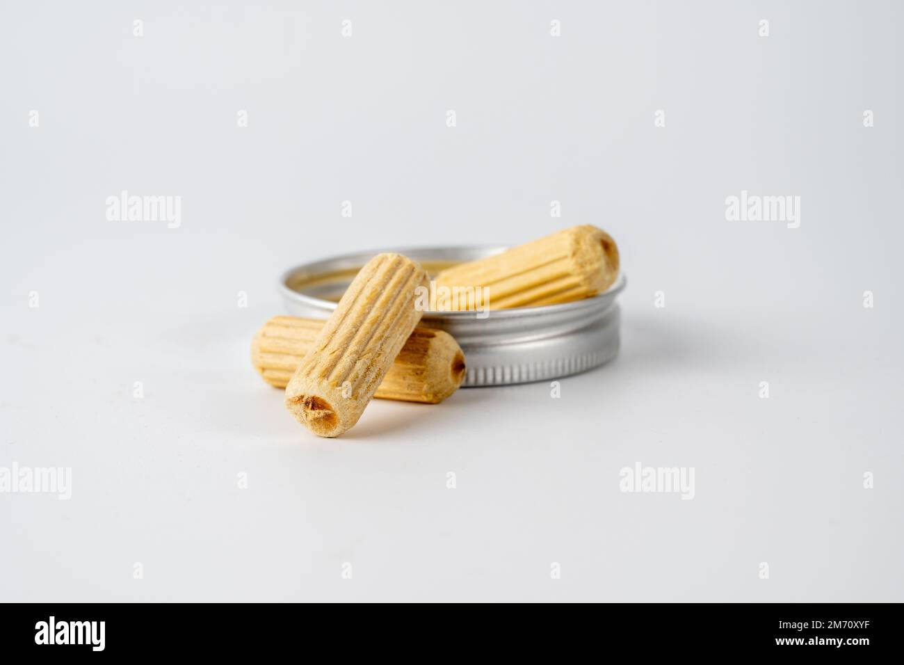 aluminium cap with hardwood ribbed woodworking dowels isolated on a ...