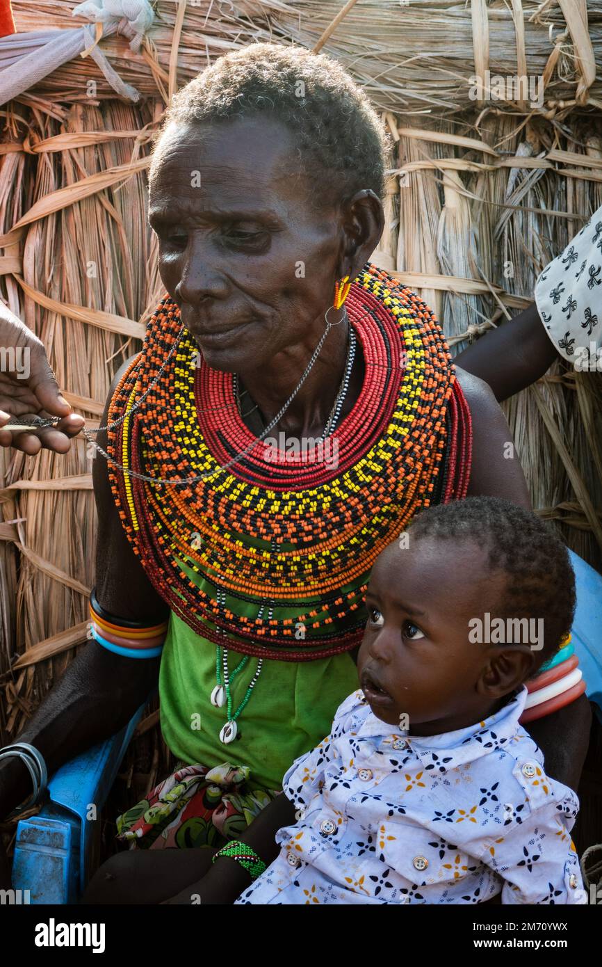 A portrait of an El Molo woman holding a child at El Molo Village in ...
