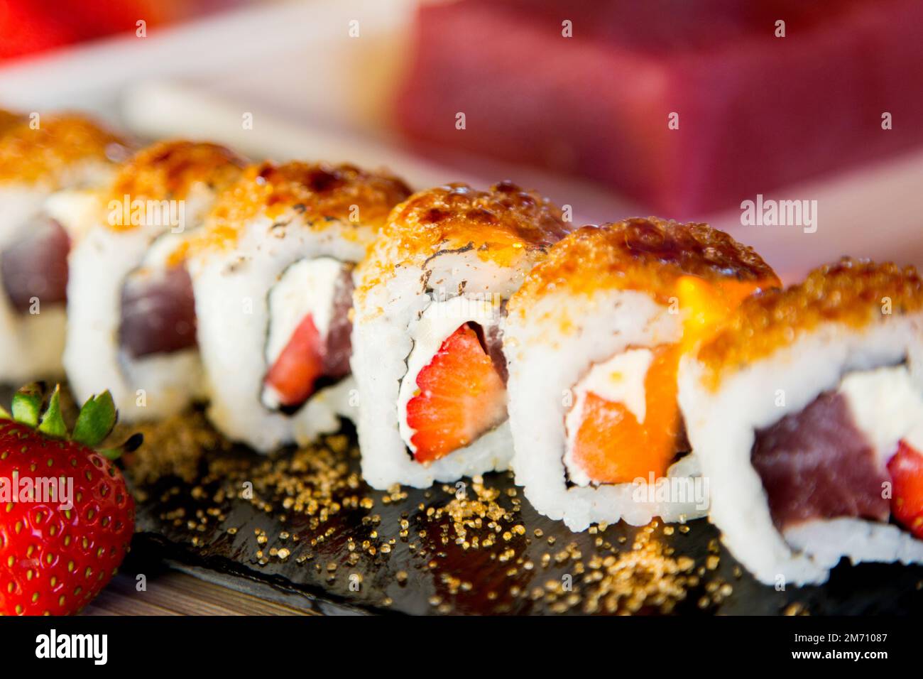 Tuna Uramaki with strawberries. Sushi rice combined with premium tuna ...