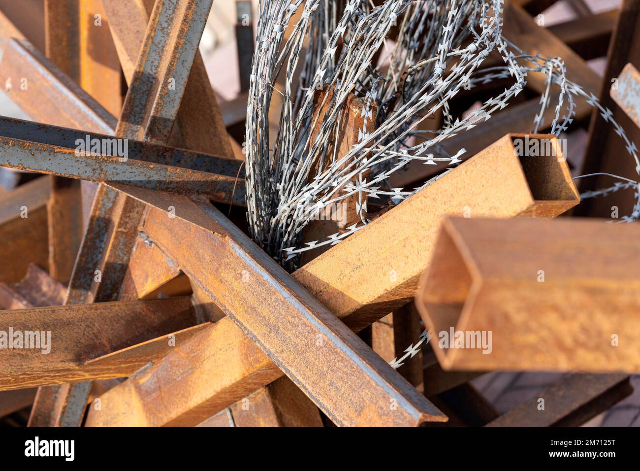 Barbed wire stretched over anti-tank hedgehogs. Fortified defense line ...