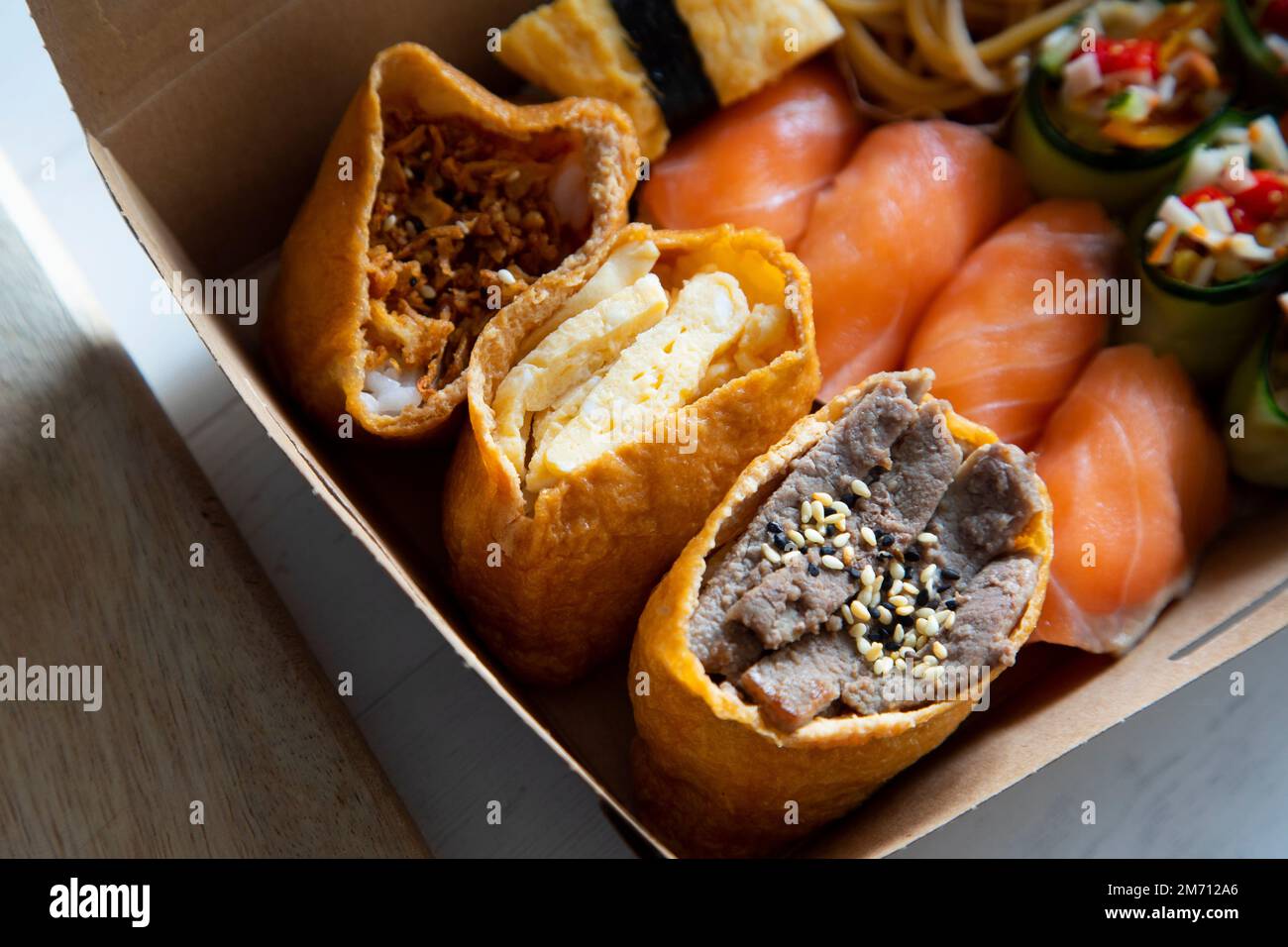Japanese lunch box with yakisoba noddles, nigiris sushi, stuffed tofu ...