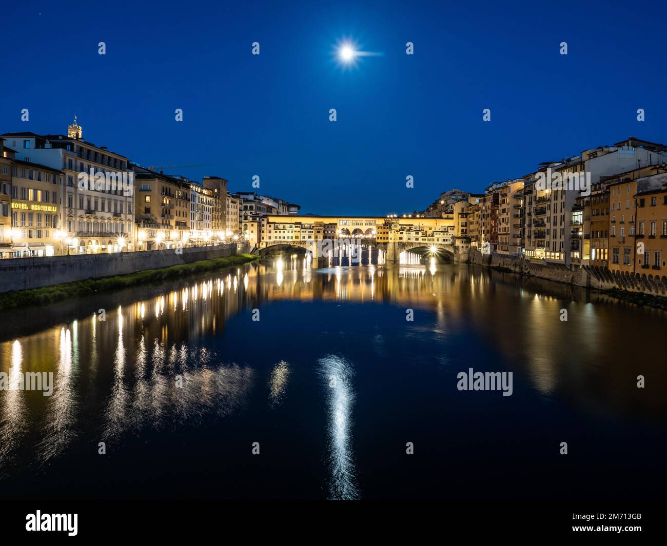 The Ponte Vecchio bridge over the river Arno, in moonlight under a full ...