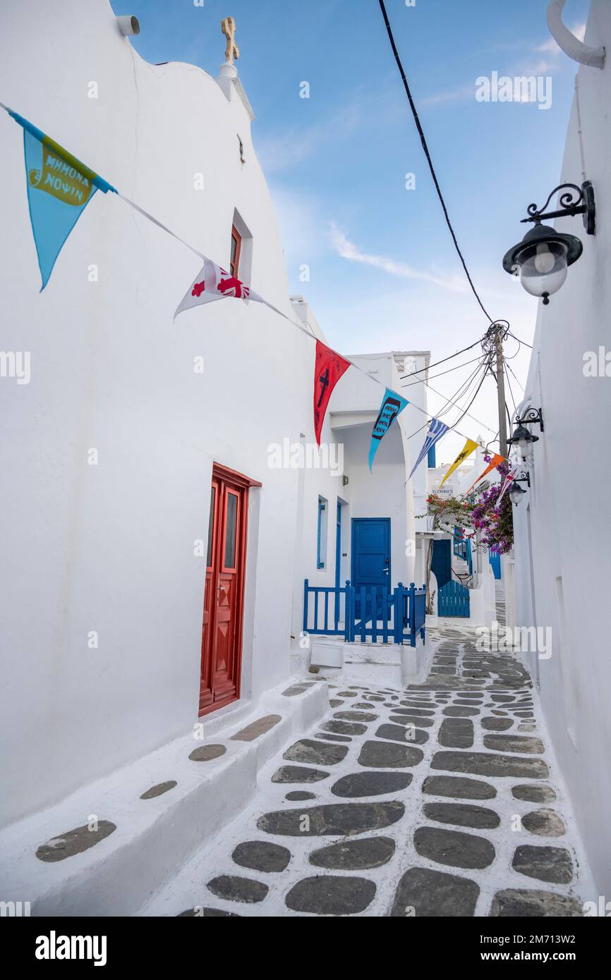 Cycladic Greek Orthodox Church decorated with flags, alleys of the old ...