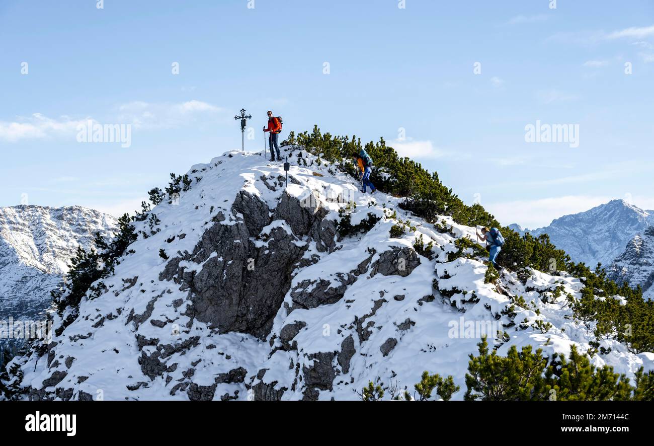 Mountaineers at the summit cross of the Weitalpspitz in winter with ...