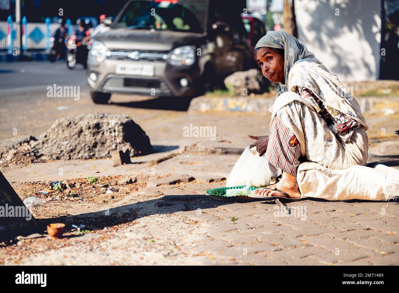 A Homeless beggar woman sitting on the street in Kolkata, India Stock ...