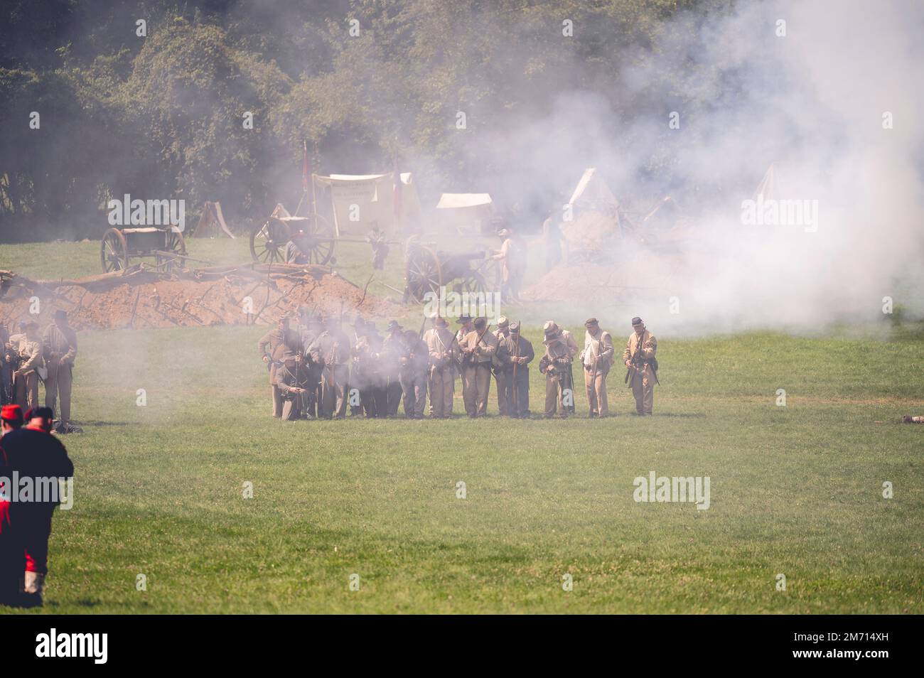 A group of soldiers in a big smoke in military camp during the day of ...