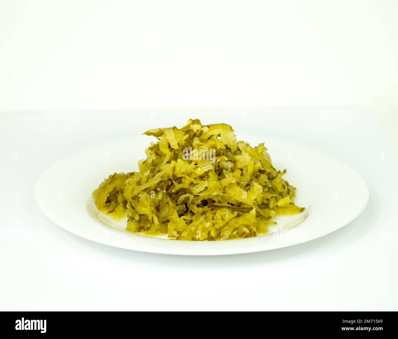 A closeup shot of a plate of sliced pickles on a white background Stock ...