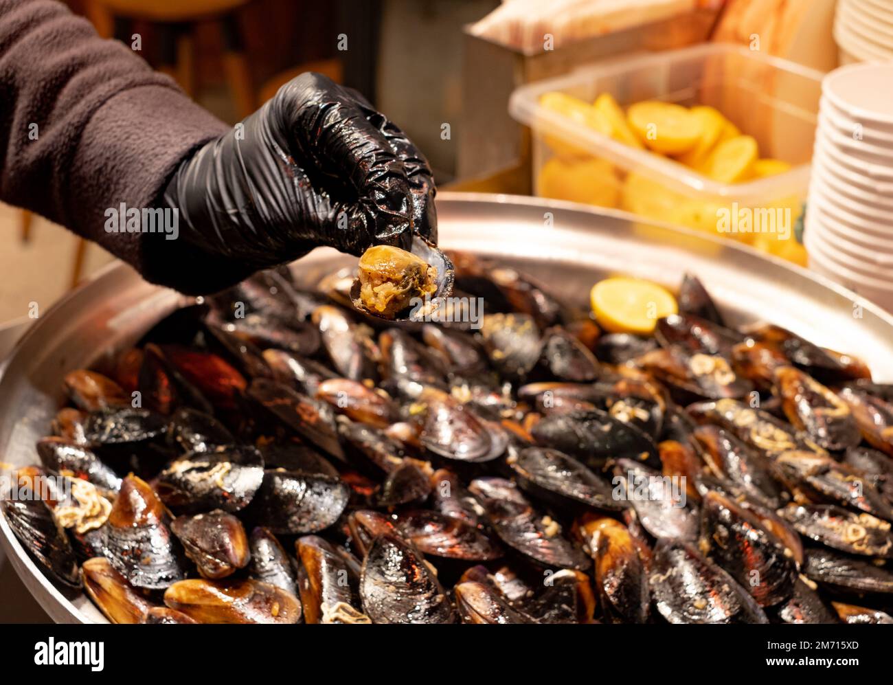 Street Flavors Stuffed Mussels.Hand Holding Mussel. Heap of Black ...