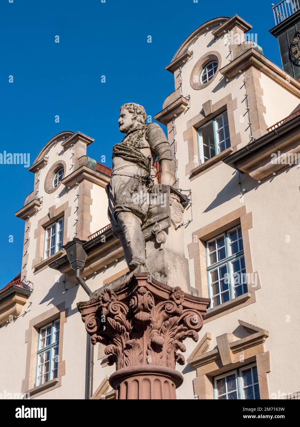 Detail of fountain with a statue of a man in front of an old building ...