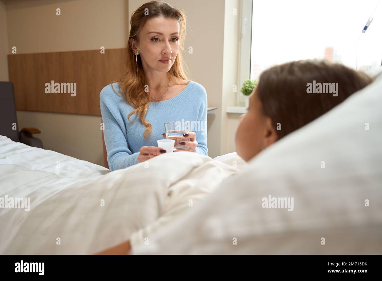 Beautiful woman gives pills and glass of water to sick girl Stock Photo ...