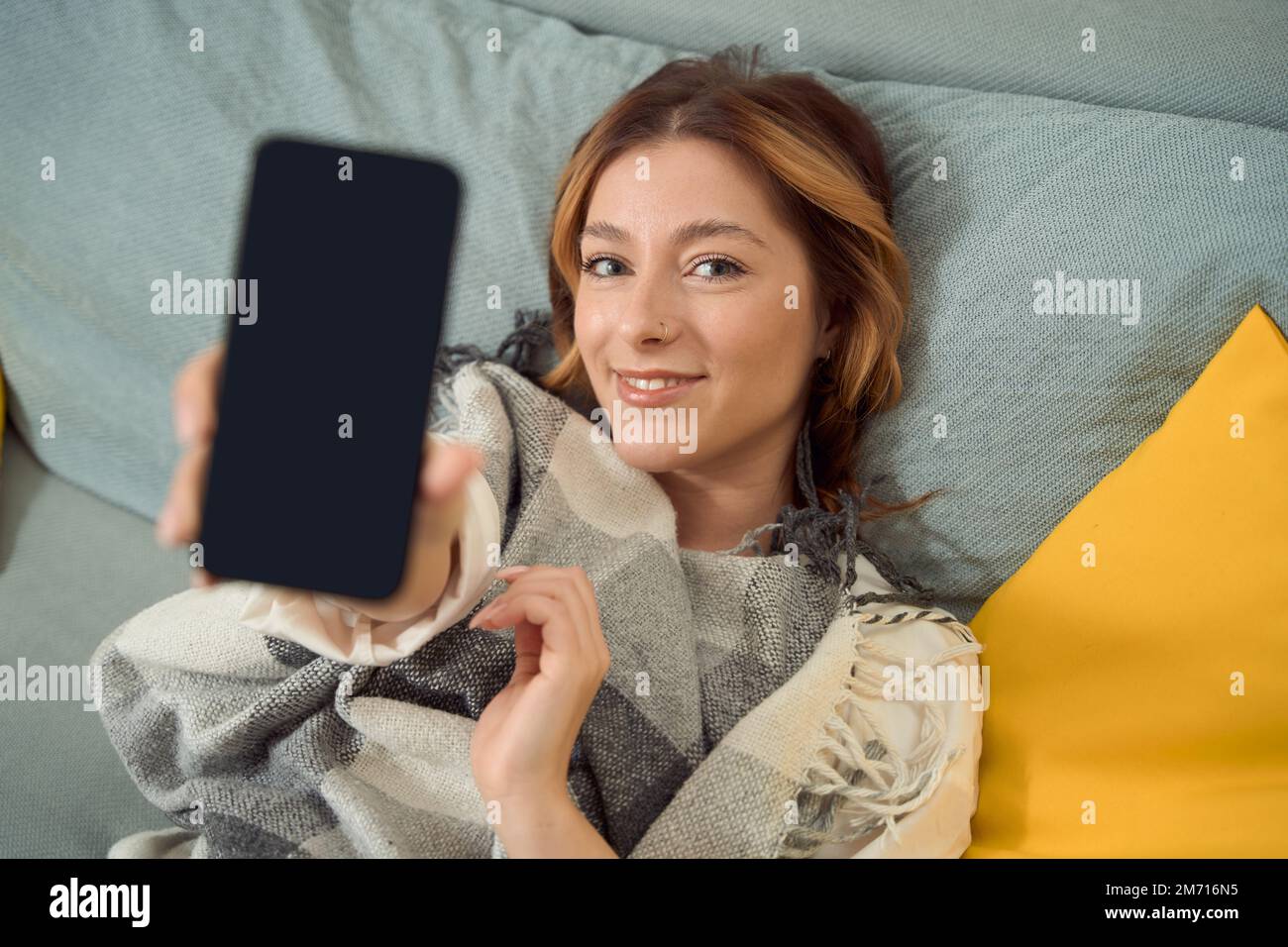 Joyous female demonstrating her cellphone before camera Stock Photo - Alamy