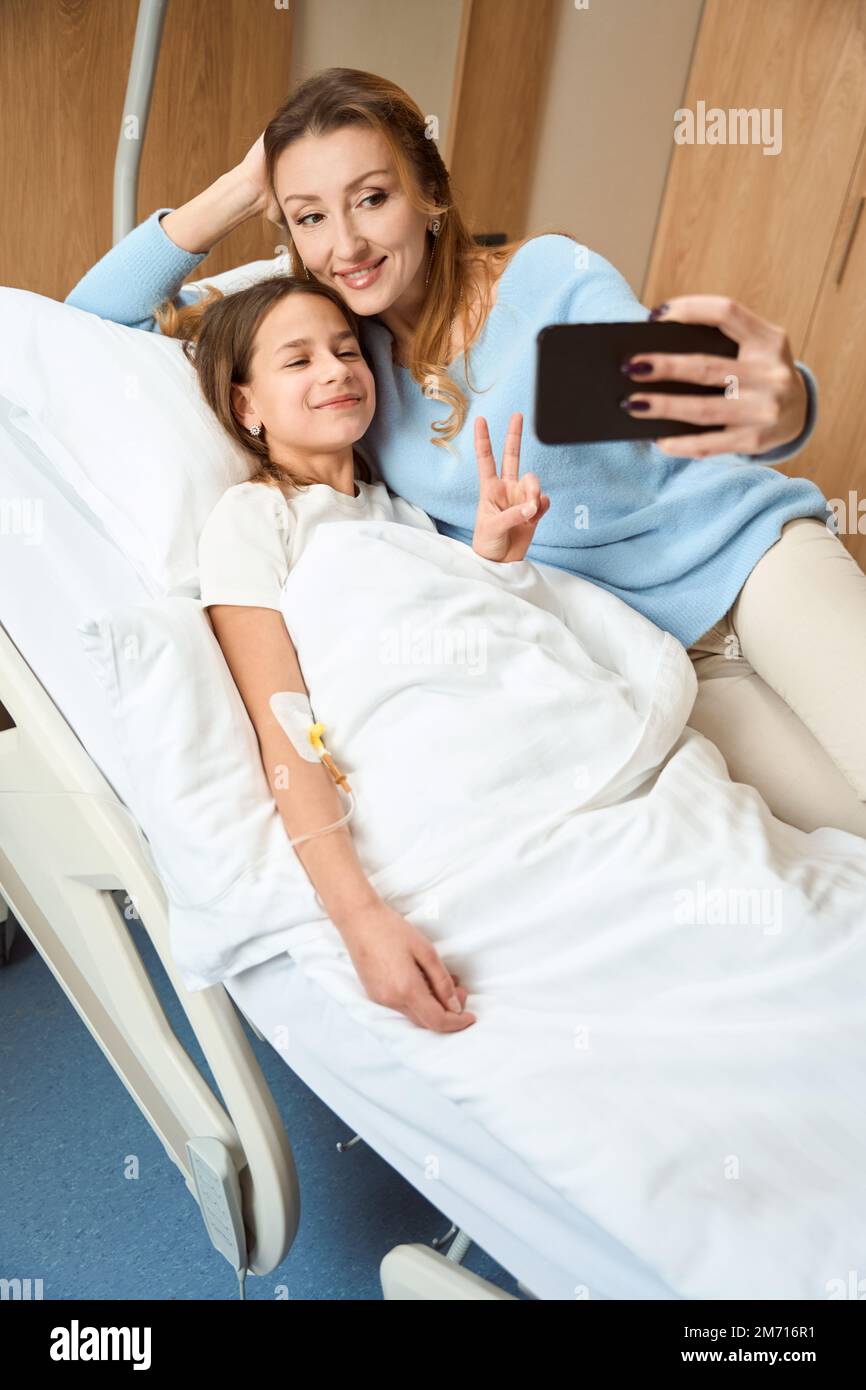 Cheerful mother and daughter look at the phone screen Stock Photo - Alamy