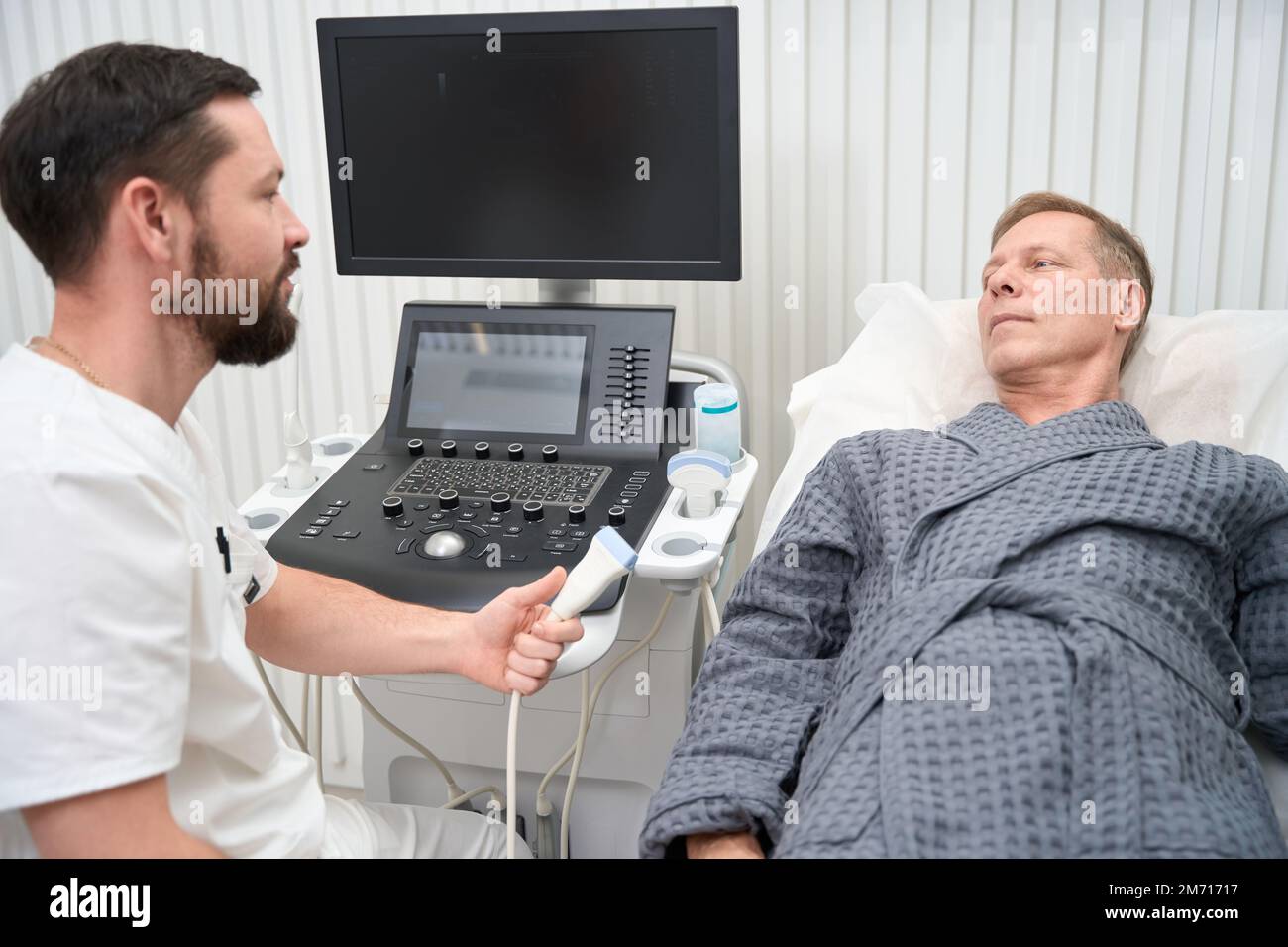 Professional orthopaedist talking with patient before medical procedure ...