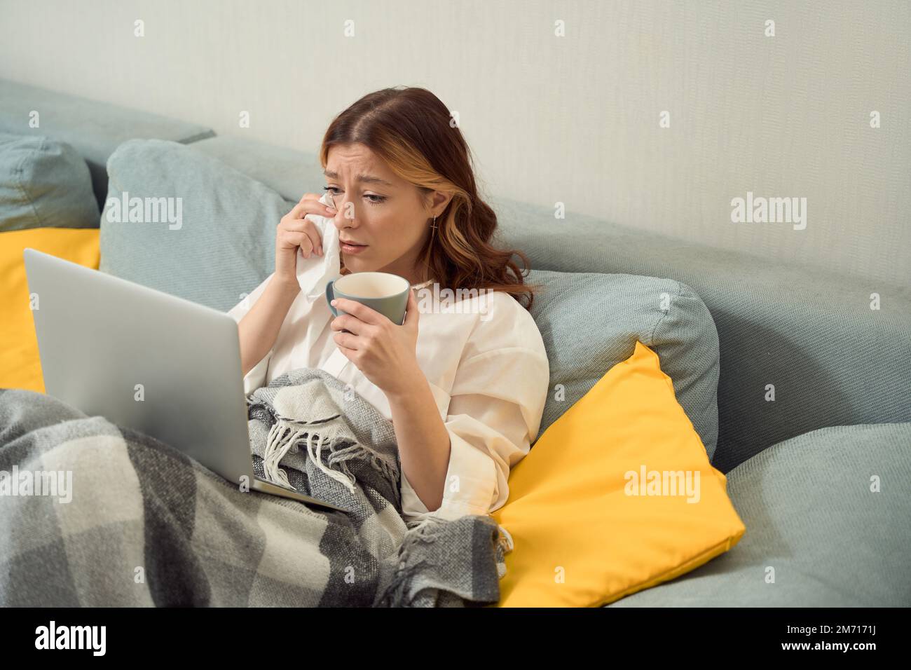 Sentimental lady crying while watching film on portable computer Stock ...