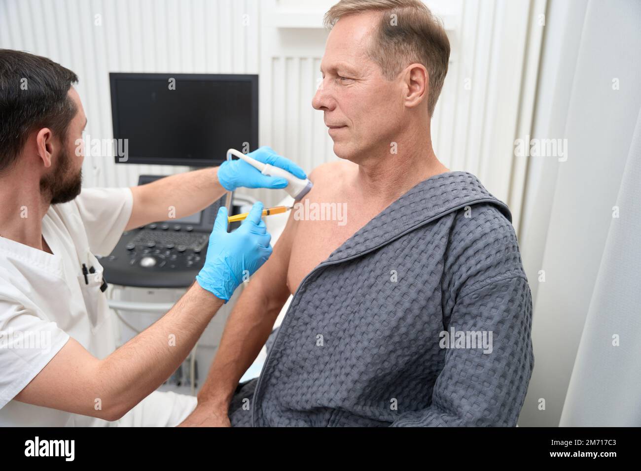 Middle-aged man going through biopsy sampling procedure at clinic Stock ...