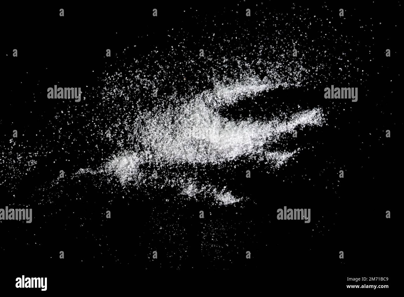 Spilled white sea salt on a black background. clear crystalline pebbles ...