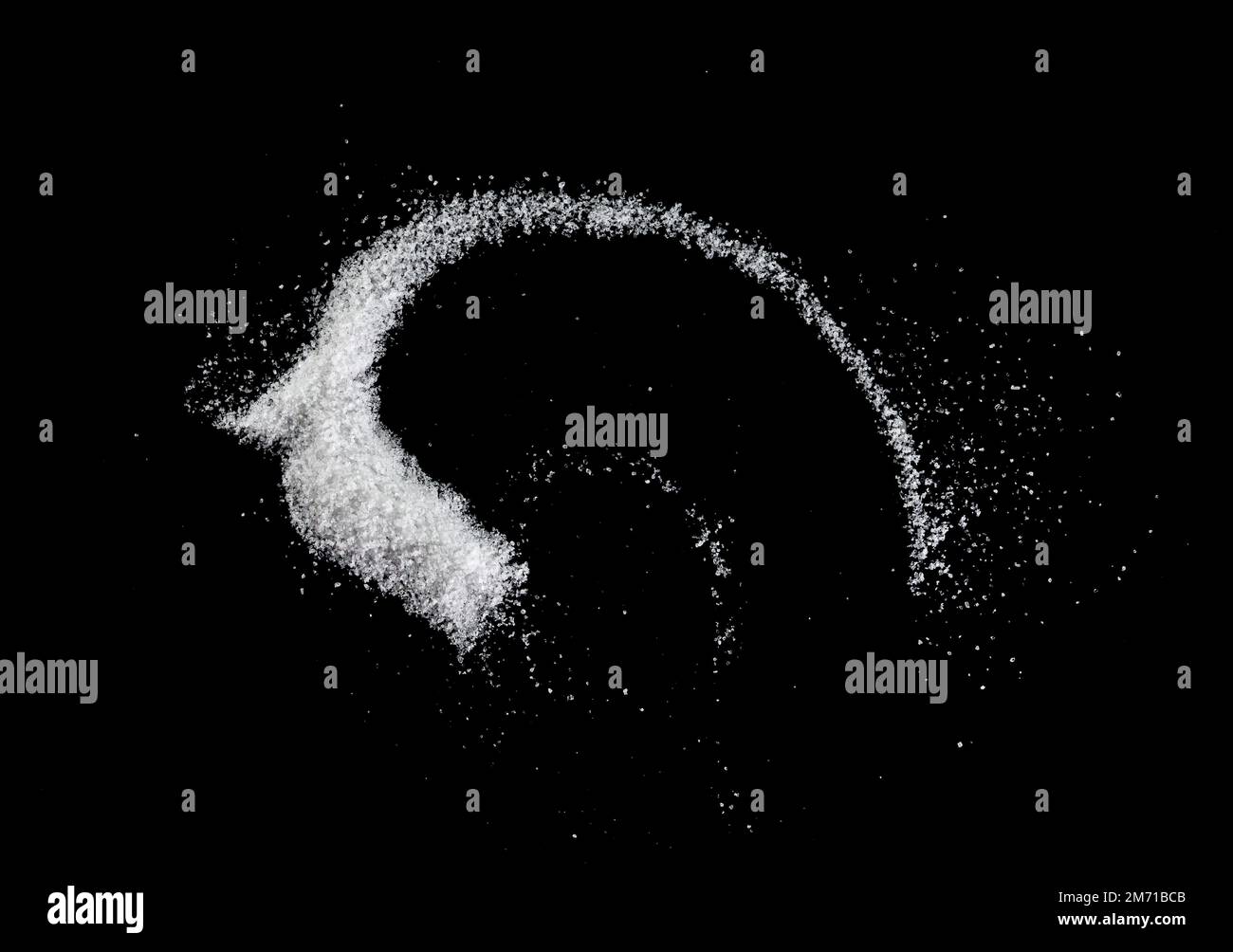 Spilled white sea salt on a black background. clear crystalline pebbles ...