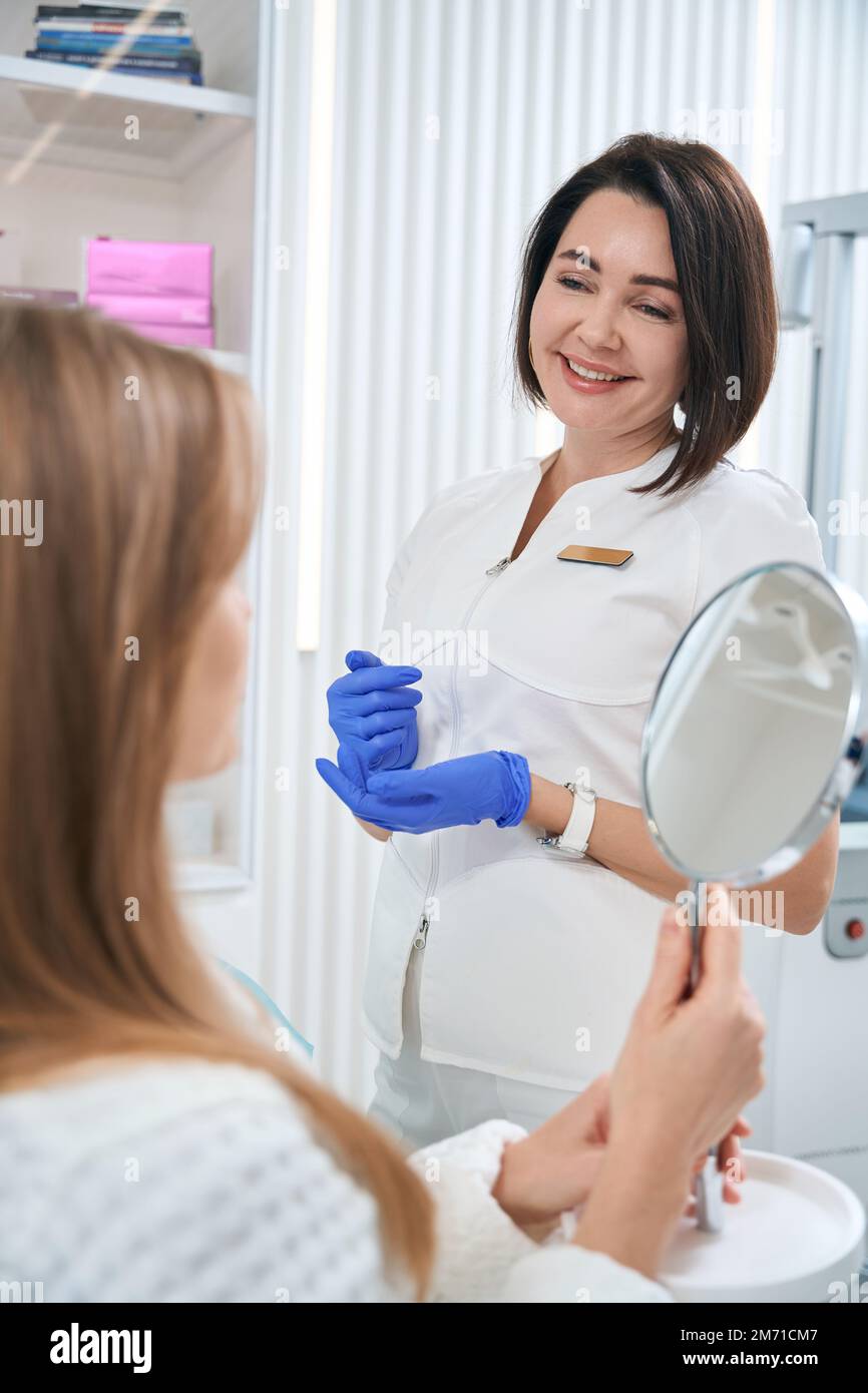 Woman cosmetologist communicates kindly with a patient Stock Photo - Alamy