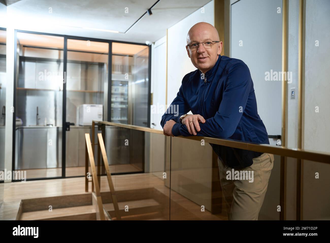 Good-natured man is standing in a foyer with modern design Stock Photo ...
