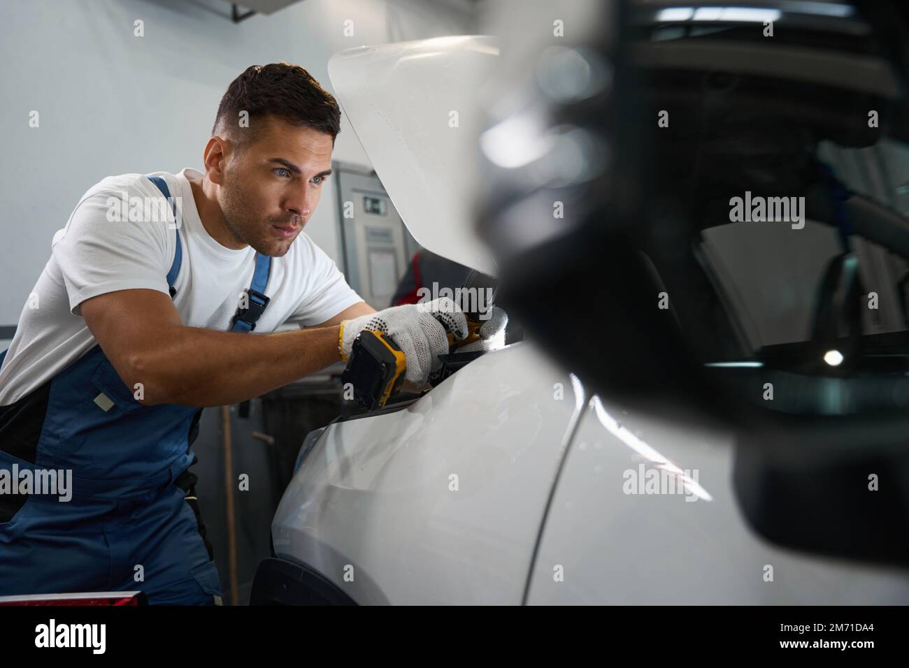Man man restoring the hood of car Stock Photo - Alamy