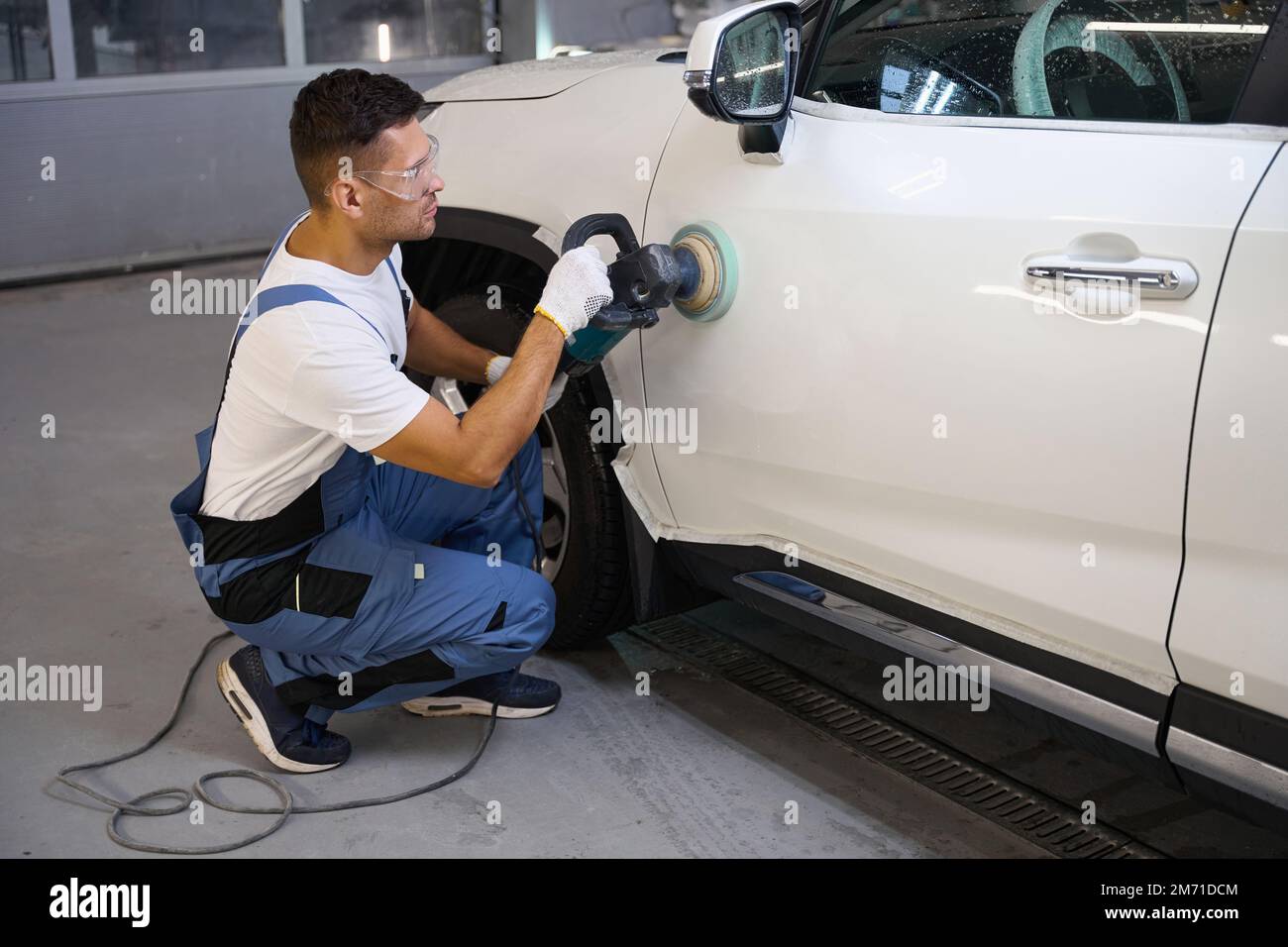 Professional worker polishing car in the garage Stock Photo - Alamy
