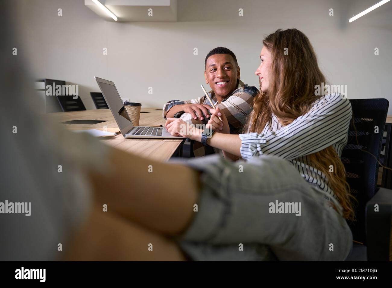 Happy woman working with laptop with her male colleague Stock Photo - Alamy