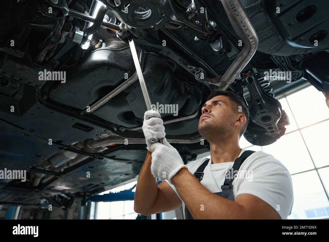 Male replacing car parts in tire shop Stock Photo - Alamy