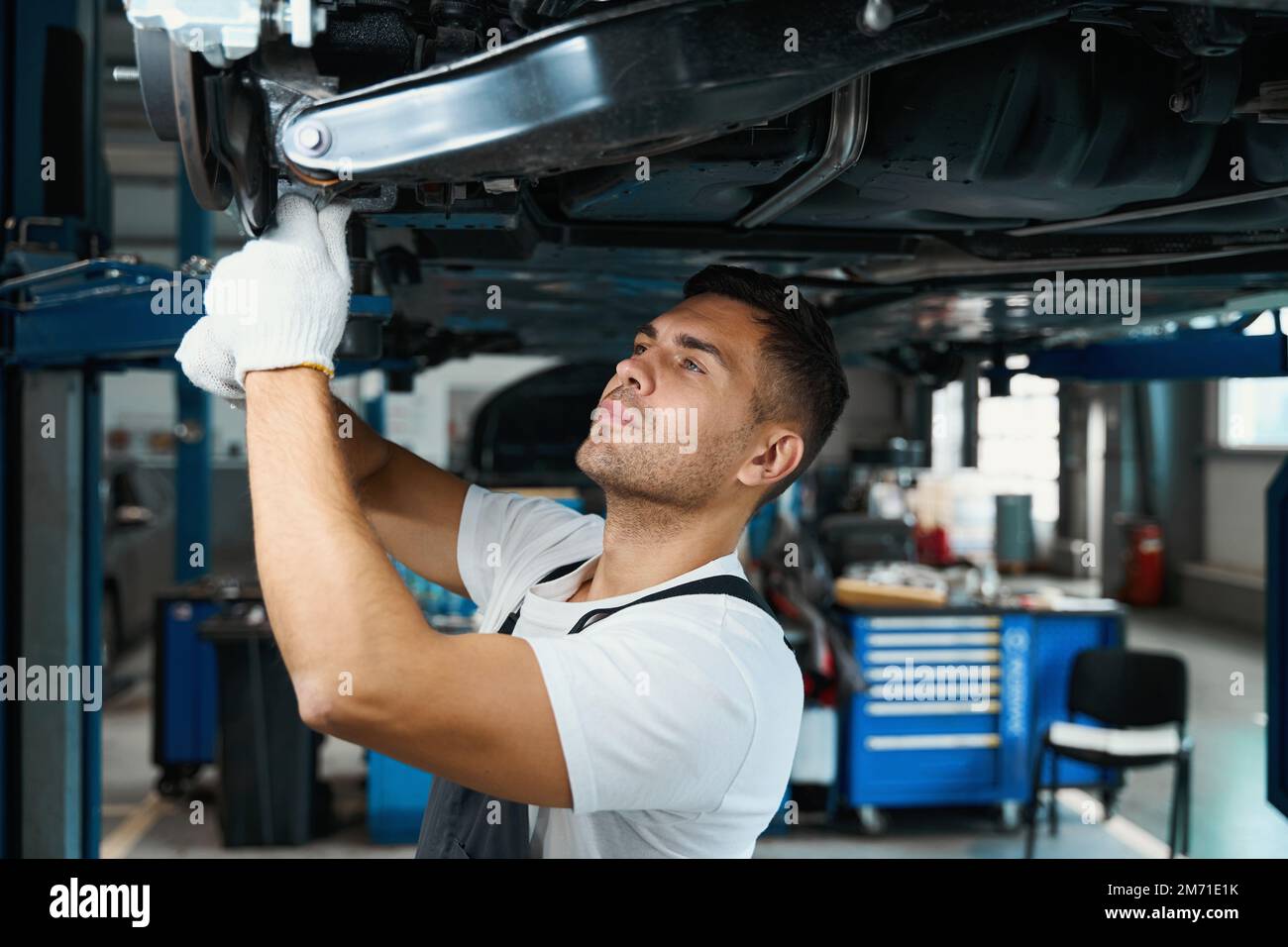 Portrait of young engineer replacing car parts in tire shop Stock Photo ...