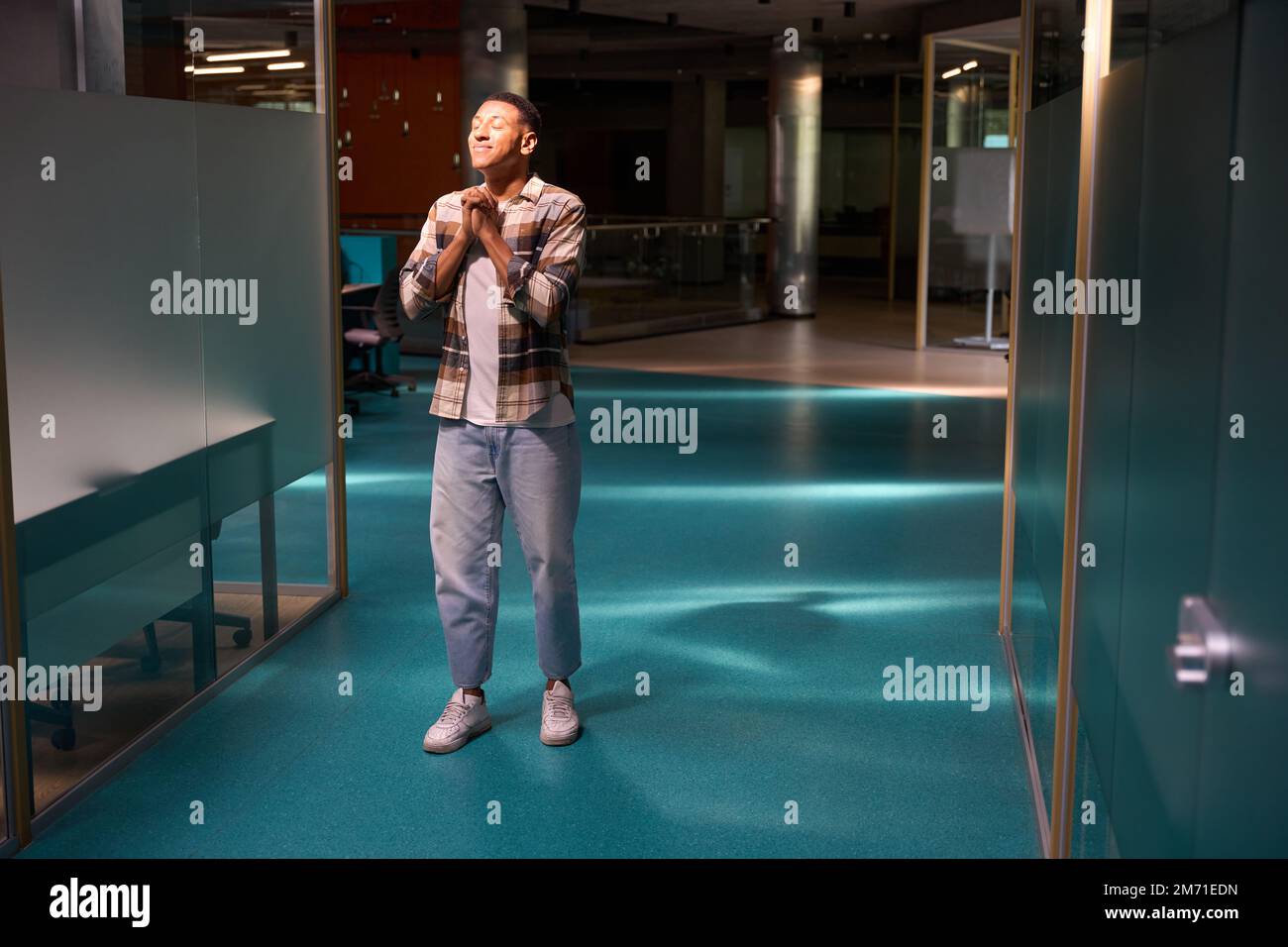 Smiling African American man praying in the office Stock Photo - Alamy