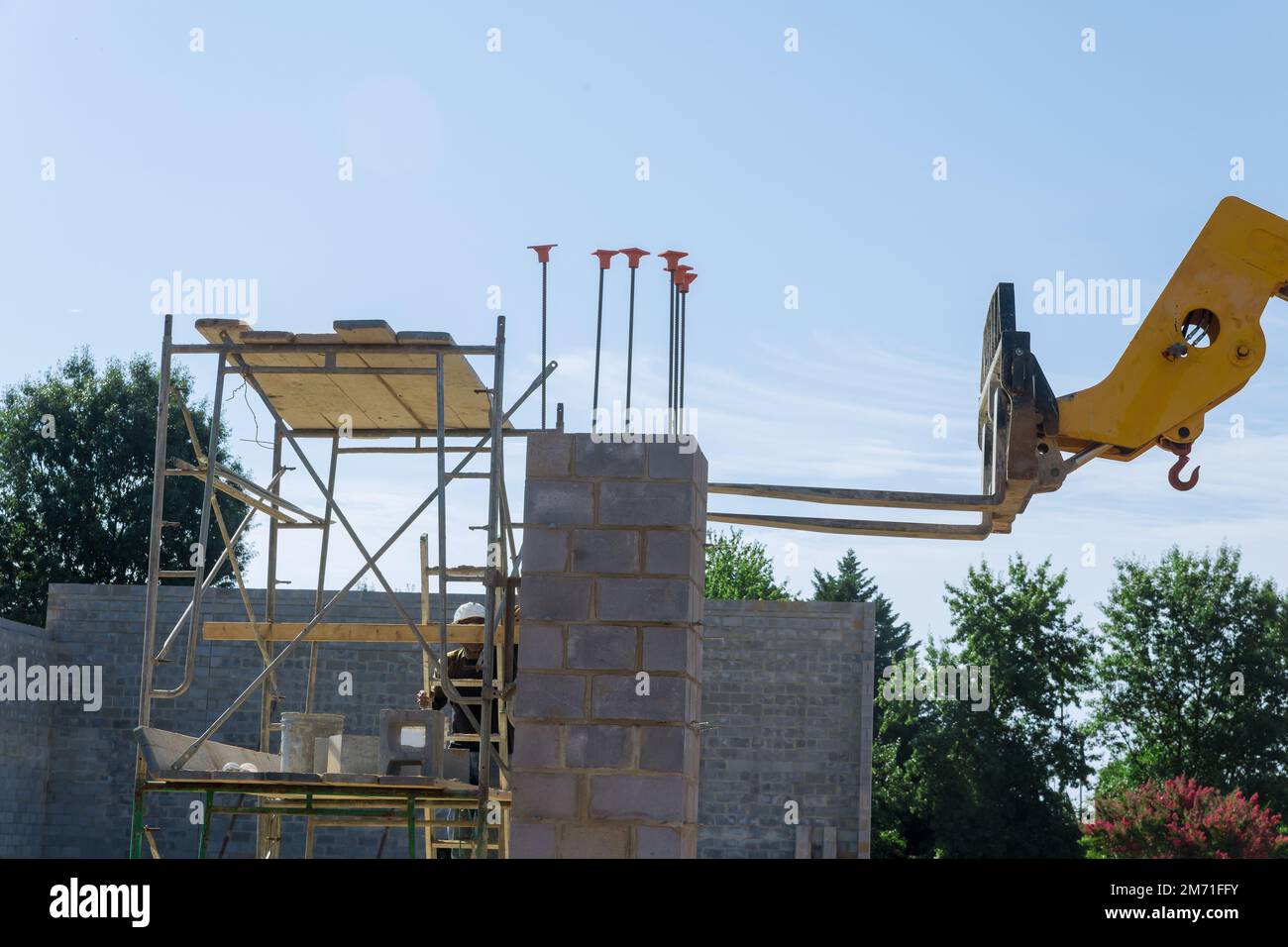 There is boom forklift being used on construction site to unload ...