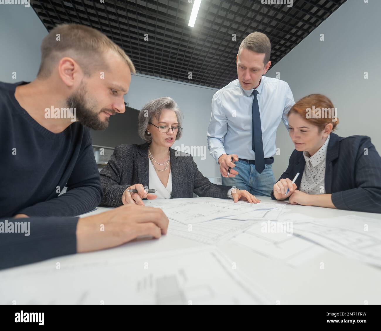 The boss gives instructions to three employees in the office conference ...