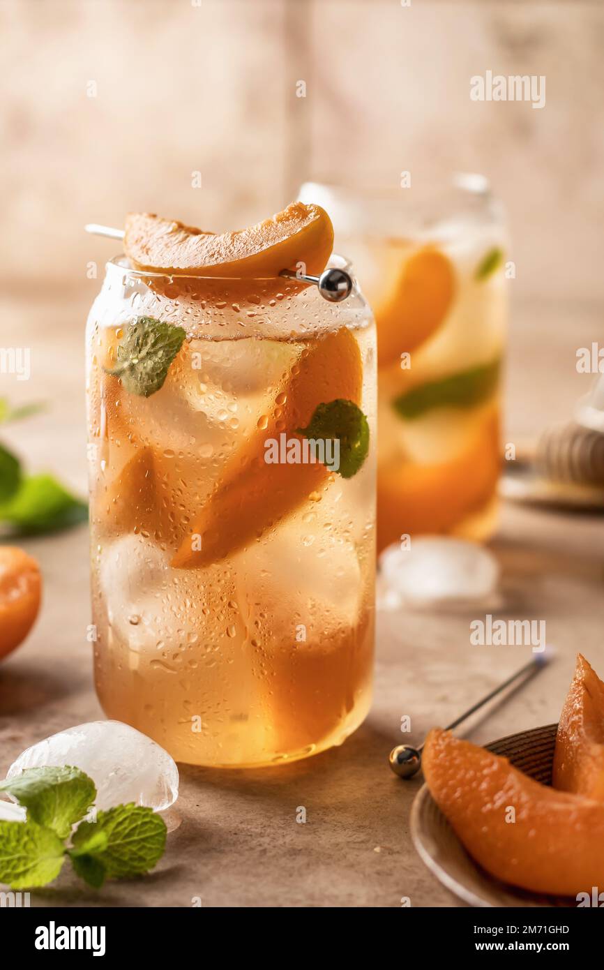Fresh cold apricot cocktail, fizz or ice tea with mint leaves and ...