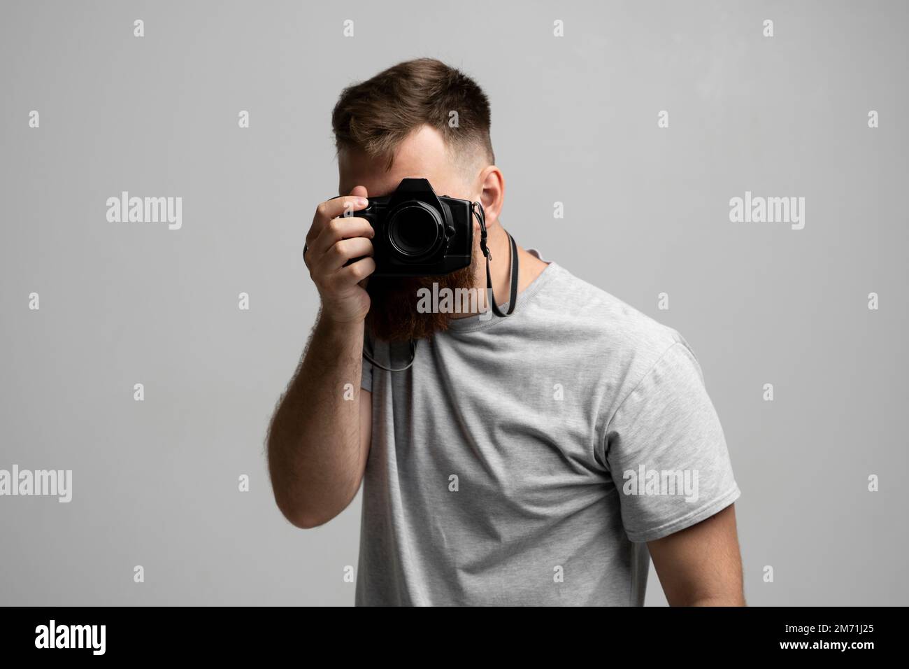 Professional bearded photographer holding a camera and ready to do a ...