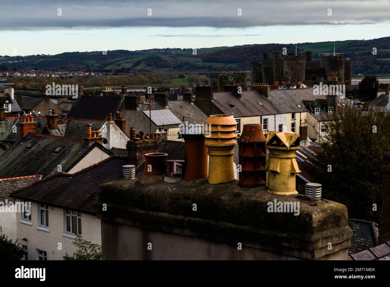 Row of unusual chimney pots castle in background. Conwy Town, north ...