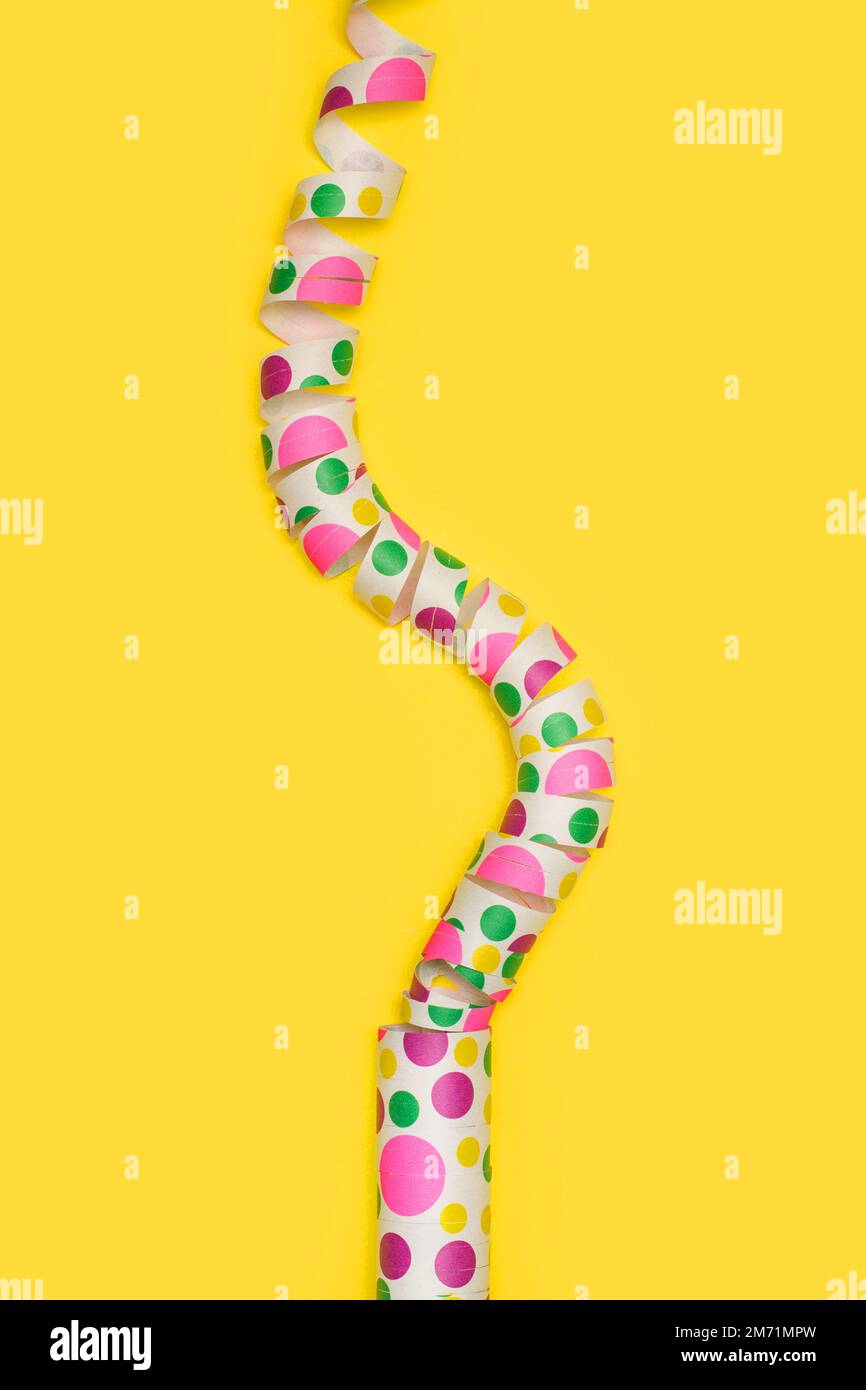 Colored paper serpentine on a yellow background with copy space Stock ...