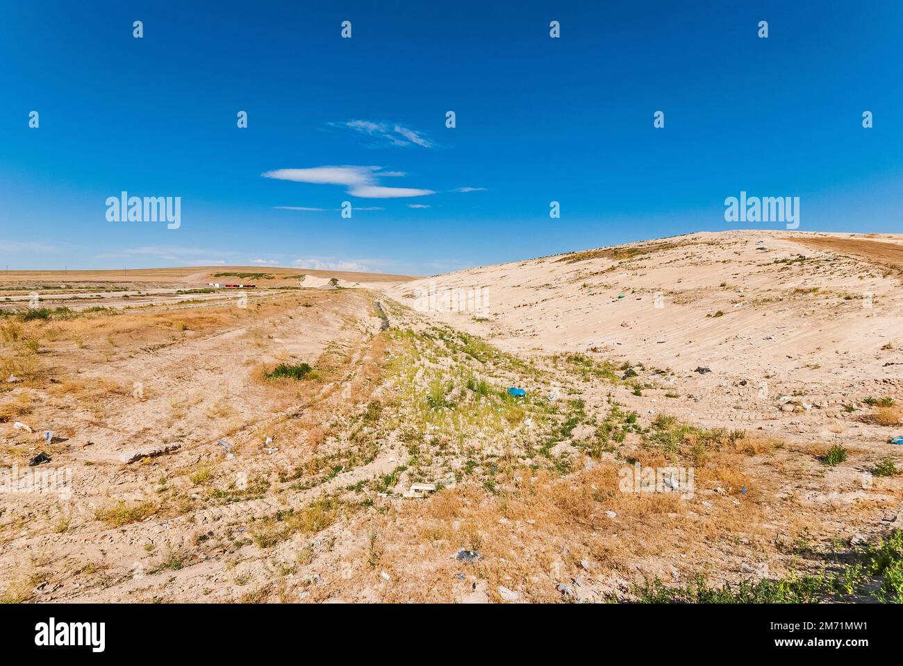 Brush and grasses on a hillside and a barren mound in an active ...