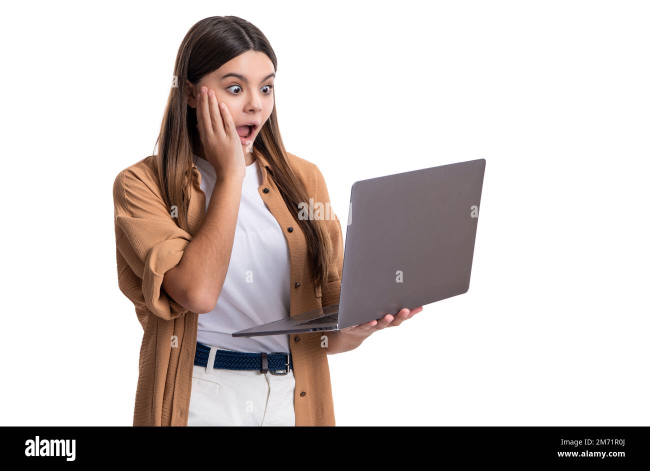surprised teen girl blogging with laptop isolated on white background ...