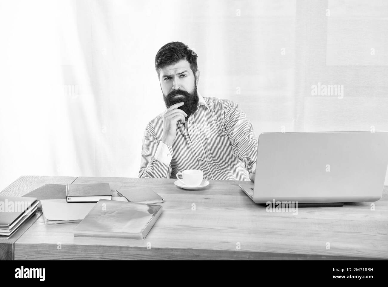 Serious man thinking sitting at office desk. Office work Stock Photo ...
