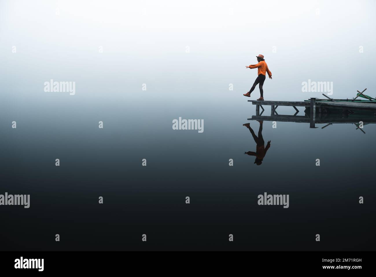 Side view of fashioned young woman sitting on wooden dock Stock Photo ...