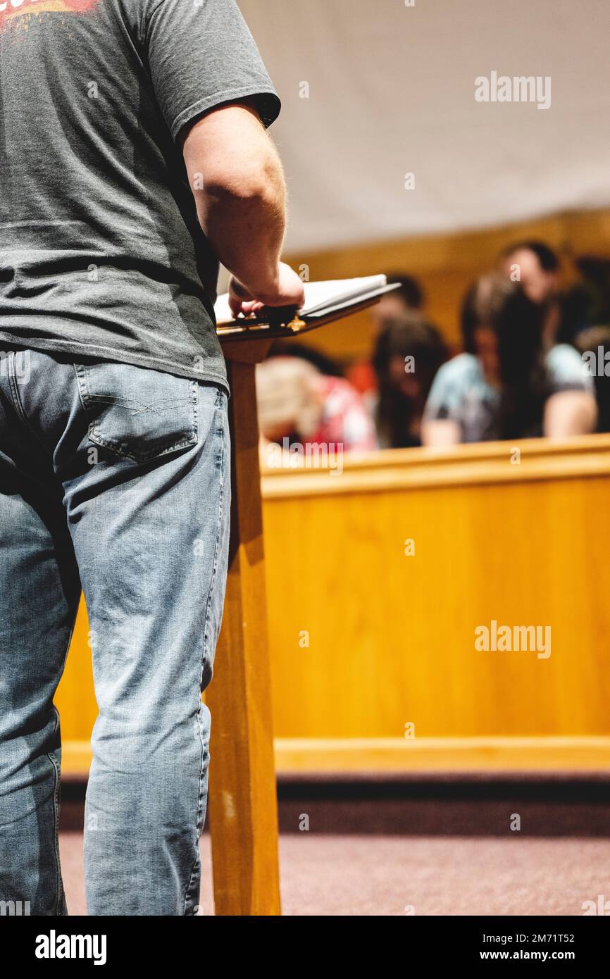 Male preaching to praying people while holding onto a pulpit Stock ...