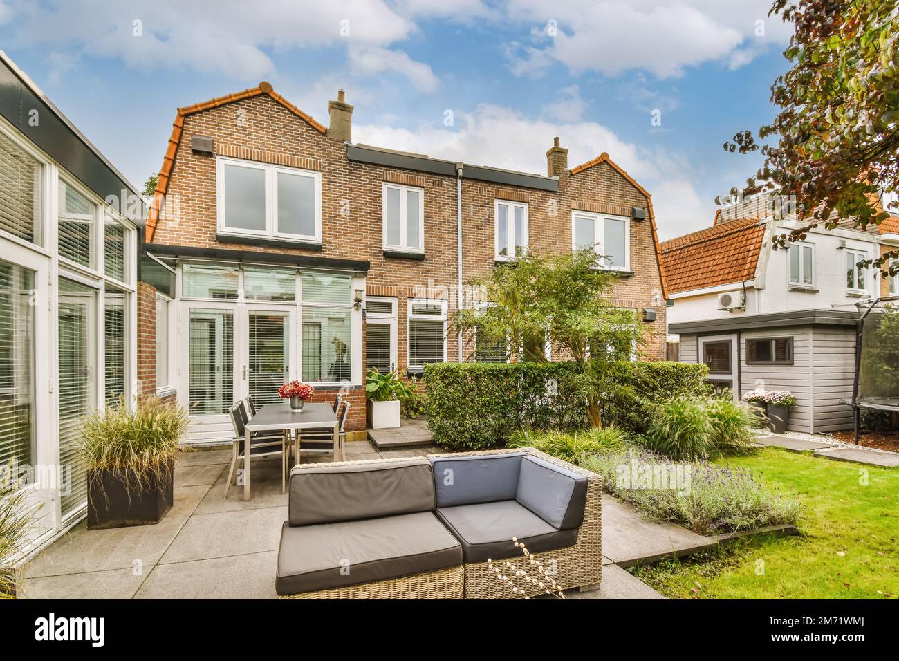 a house with an outdoor seating area in the back yard, and some plants ...