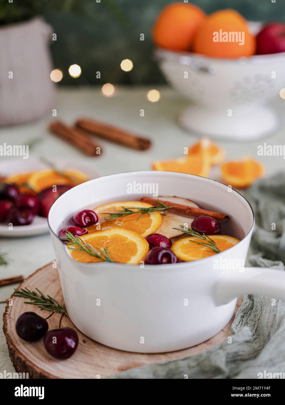 Christmas punch with cherries, oranges and rosmary, in a white pot ...