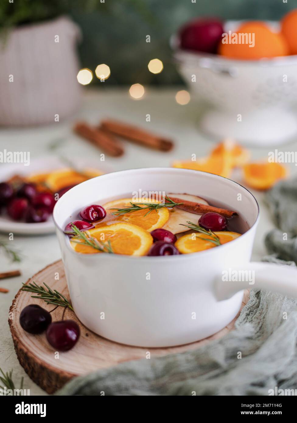 Christmas punch with cherries, oranges and rosmary, in a white pot ...