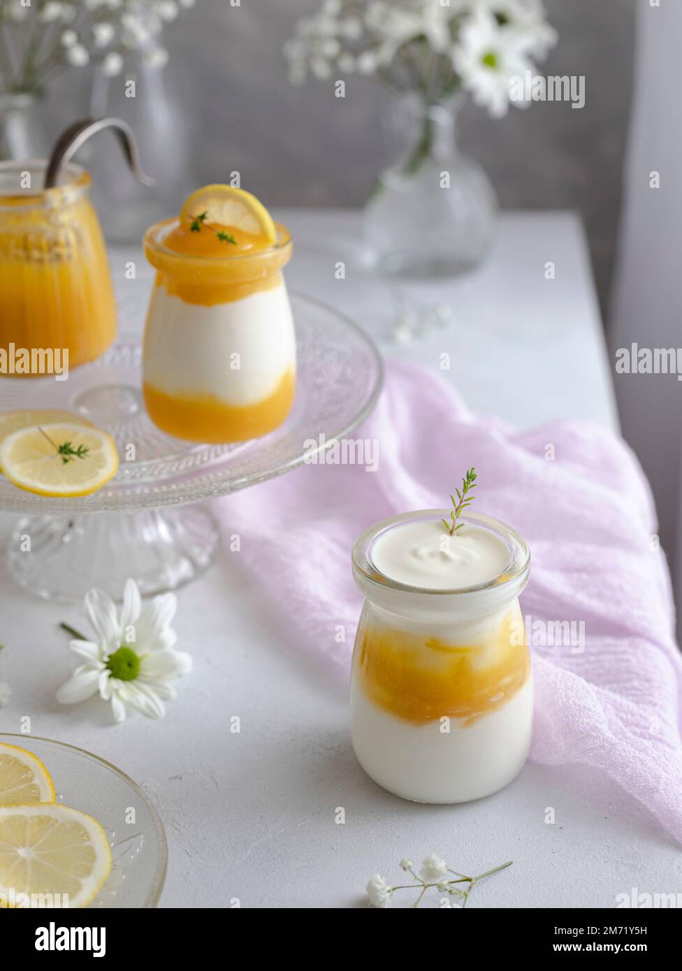 Lemon curd and greek yogurt with thyme in glass jars. Soft romantic ...