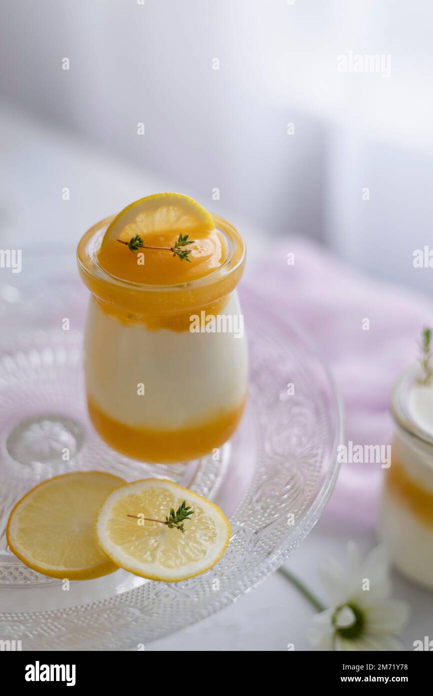 Lemon curd and greek yogurt with thyme in glass jars. Soft romantic ...